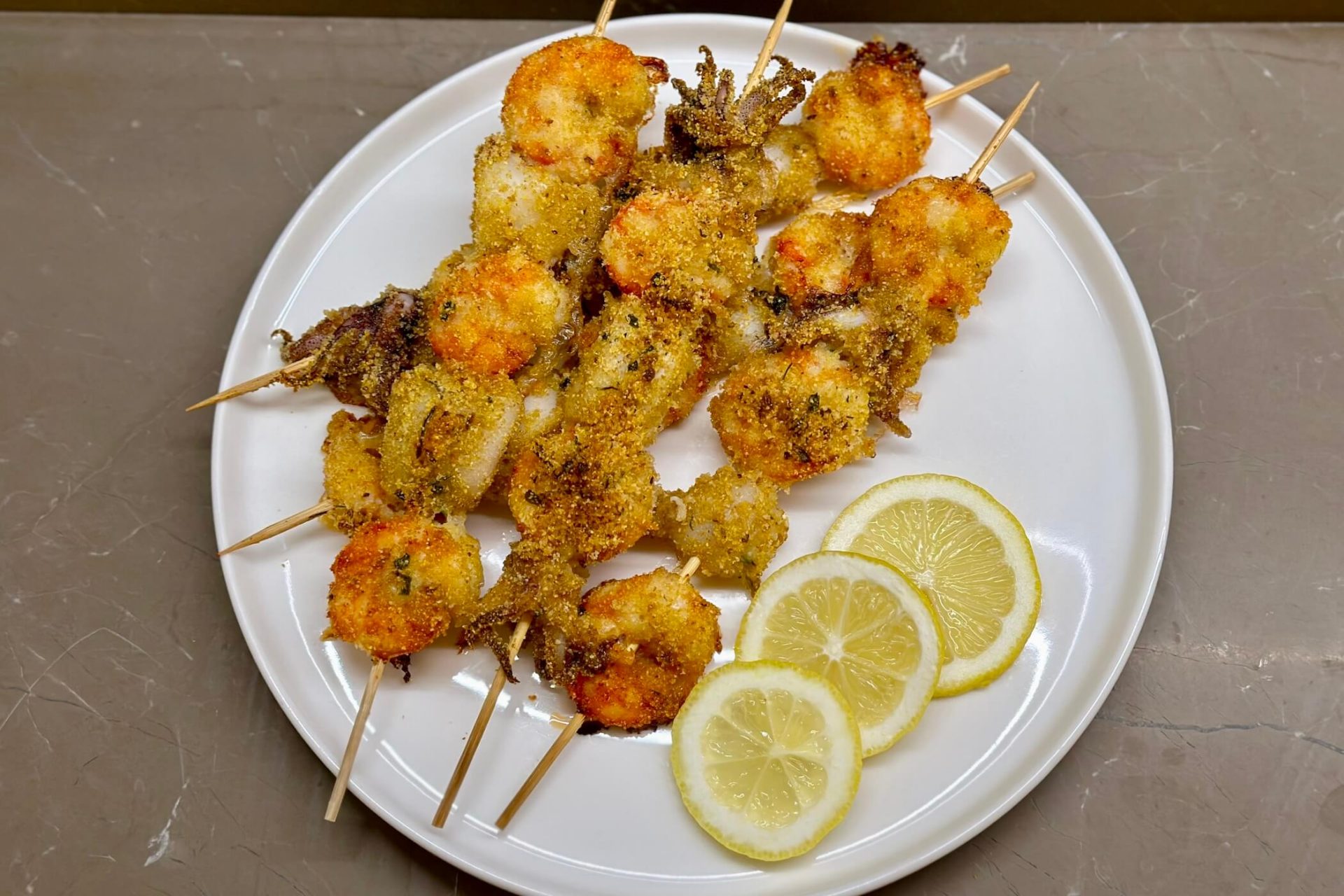 Spiedini di gamberi e calamari gratinati, la ricetta - MoltoFood